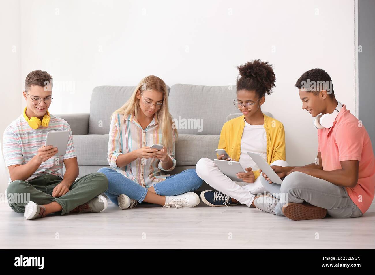 Teenagers with different devices at home Stock Photo - Alamy