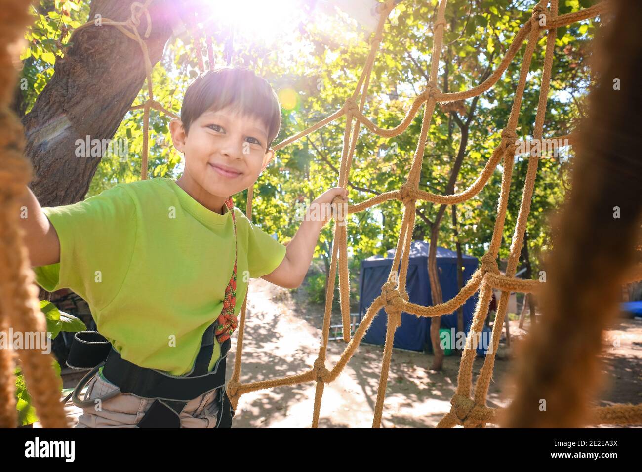 Little boy climbing in adventure park Stock Photo - Alamy