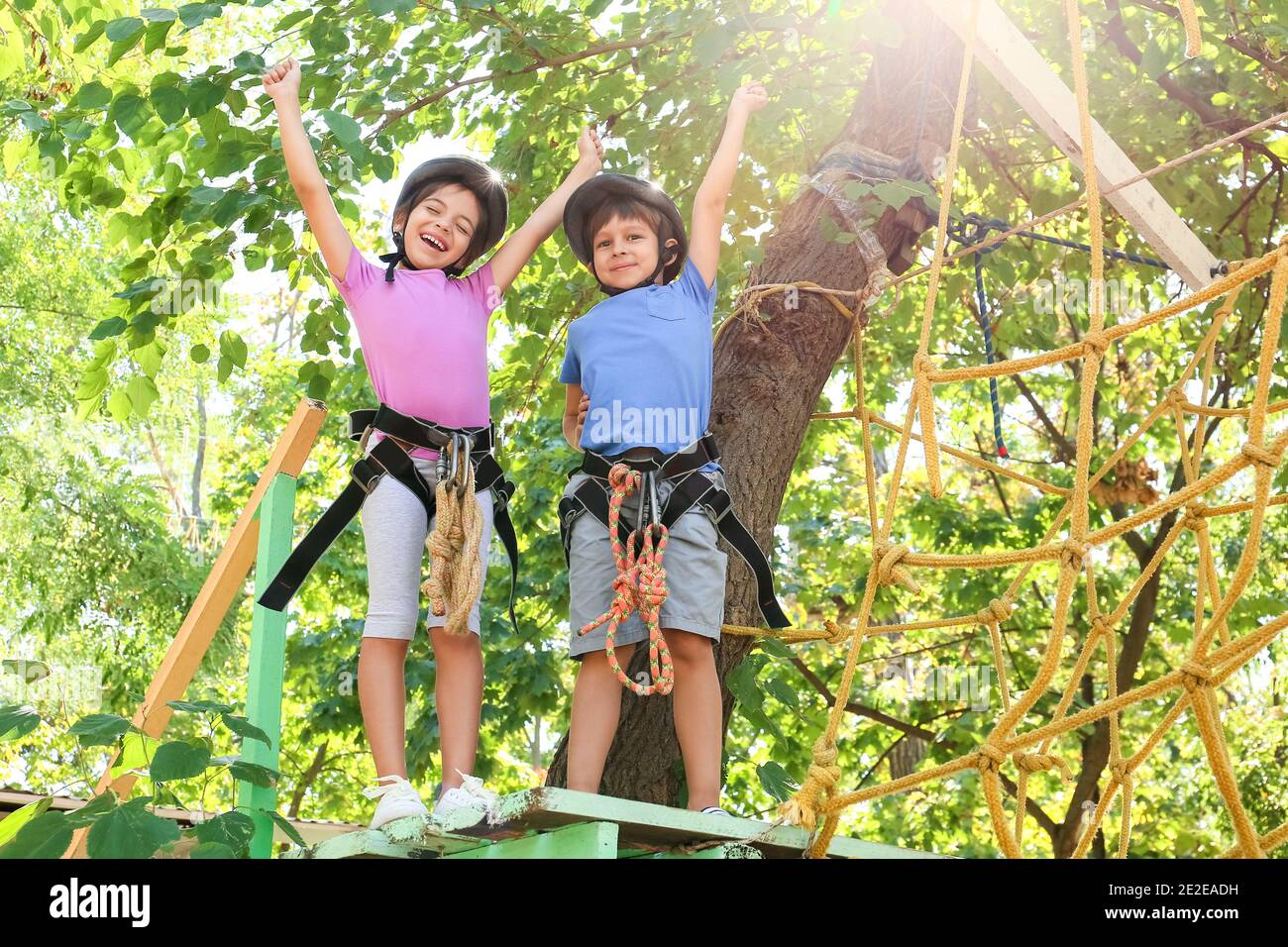 Happy children climbing in adventure park Stock Photo - Alamy