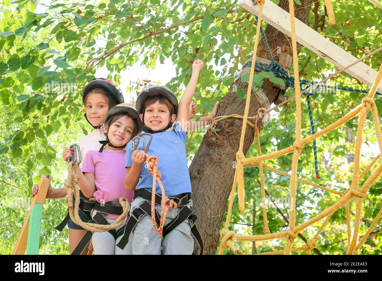 Happy children climbing in adventure park Stock Photo - Alamy