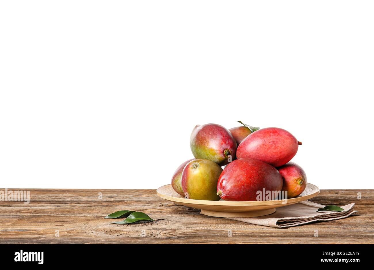 Plate with sweet ripe mangoes on table against white background Stock ...