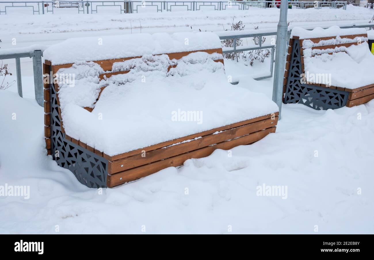 A bench in a winter park covered with snow Stock Photo - Alamy
