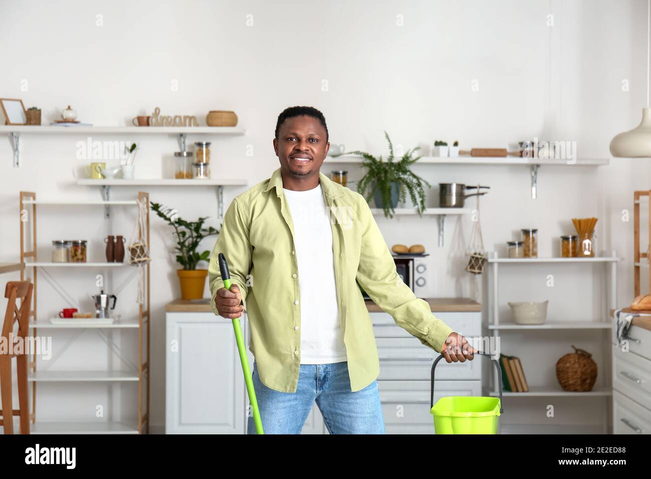 African-American man mopping floor in kitchen Stock Photo - Alamy