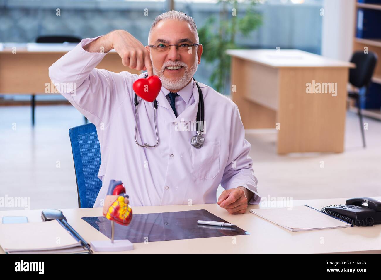 Old doctor cardiologist working in the clinic Stock Photo - Alamy