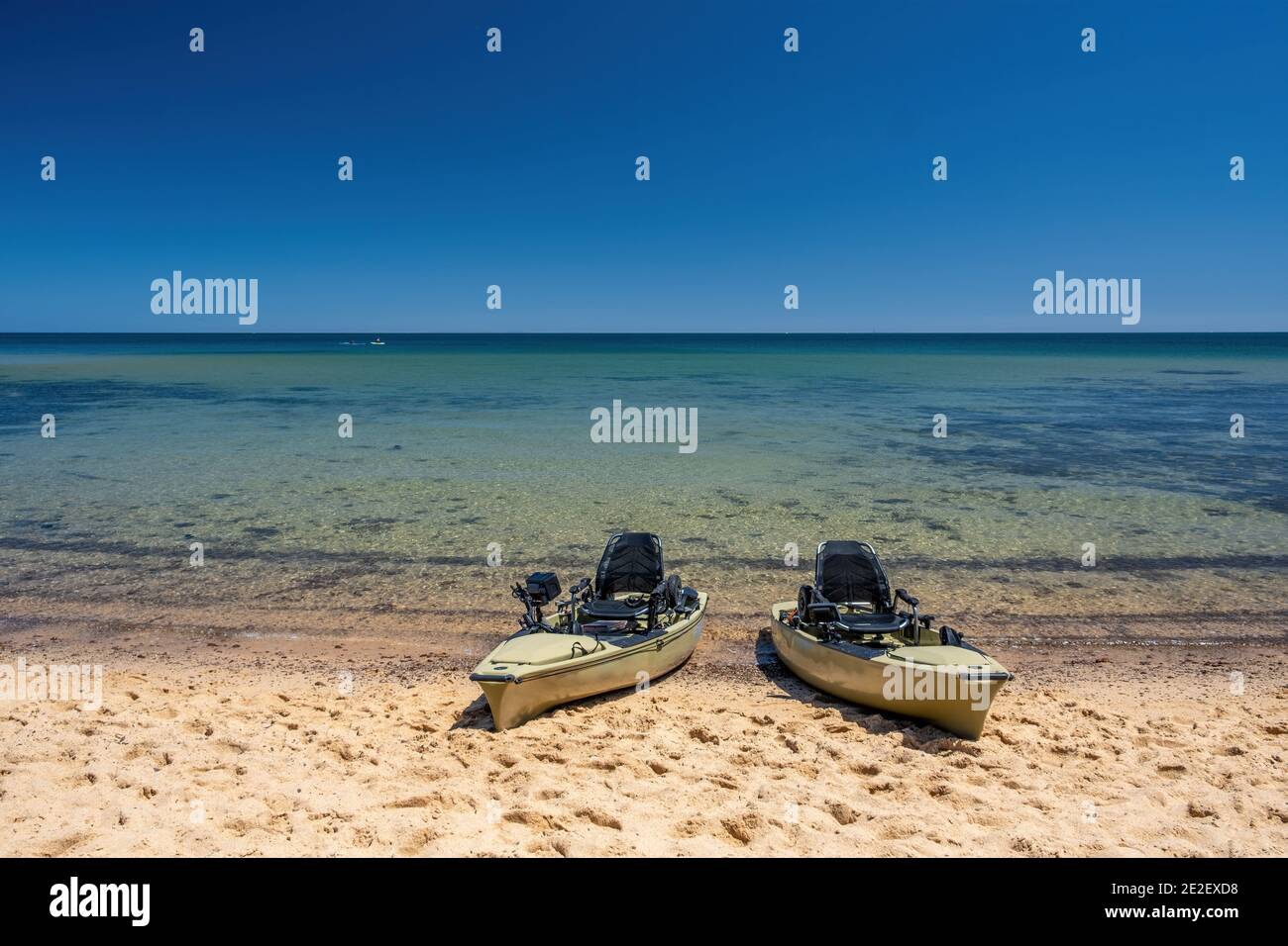 Two fishing kayaks on a beach with beautiful turquoise shallow water ...