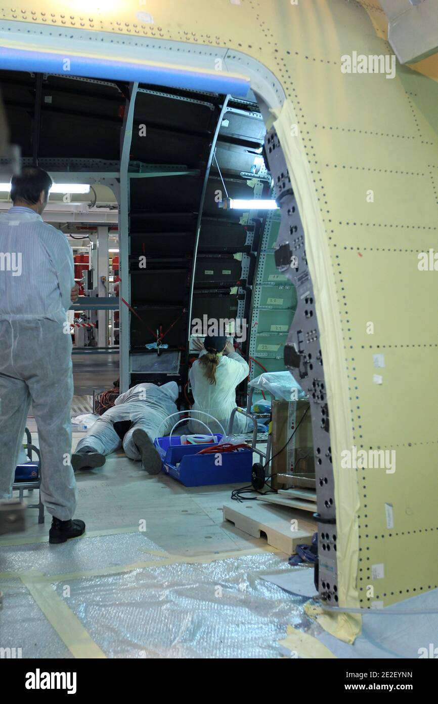 Airbus employees work in the cockpit section of an A350 Airbus airplane ...