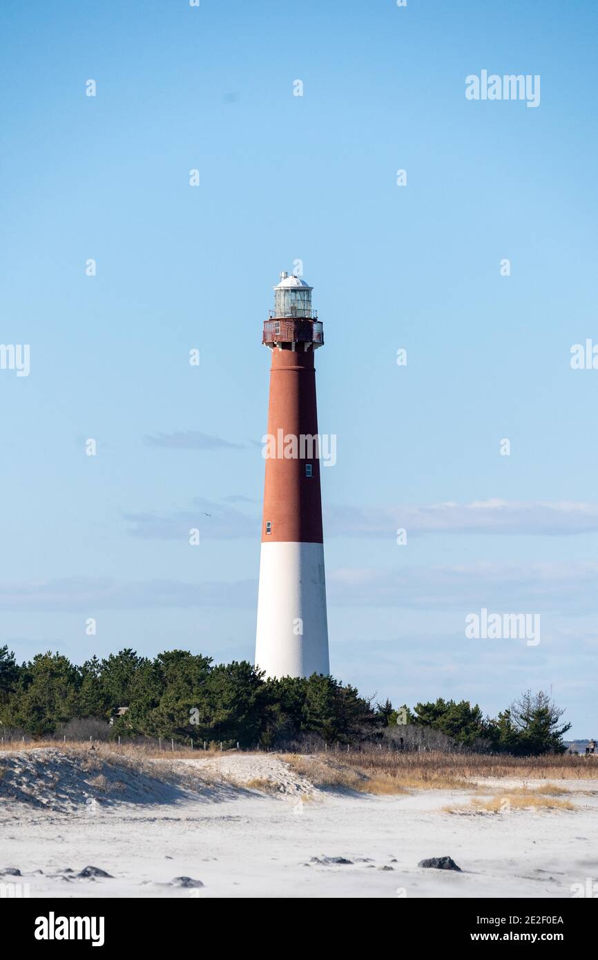 Vertical shot of a lighthouse at shore against a blue sky Stock Photo ...