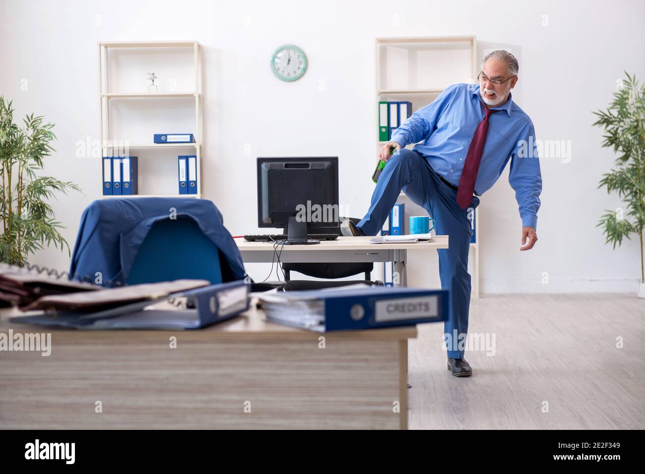 Senior male employee drinking alcohol in the office Stock Photo - Alamy