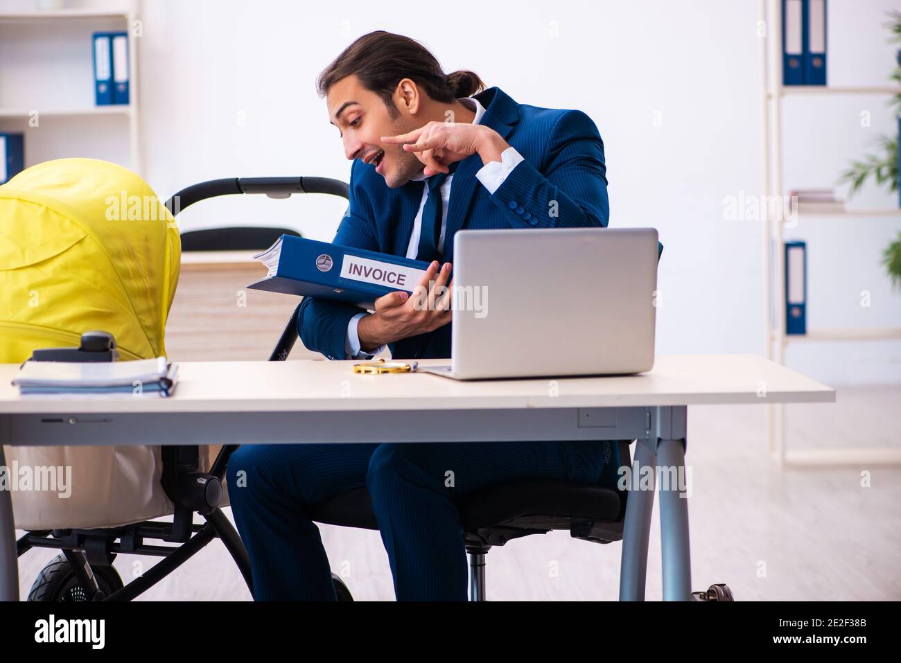 Young employee looking after kid at workplace Stock Photo - Alamy