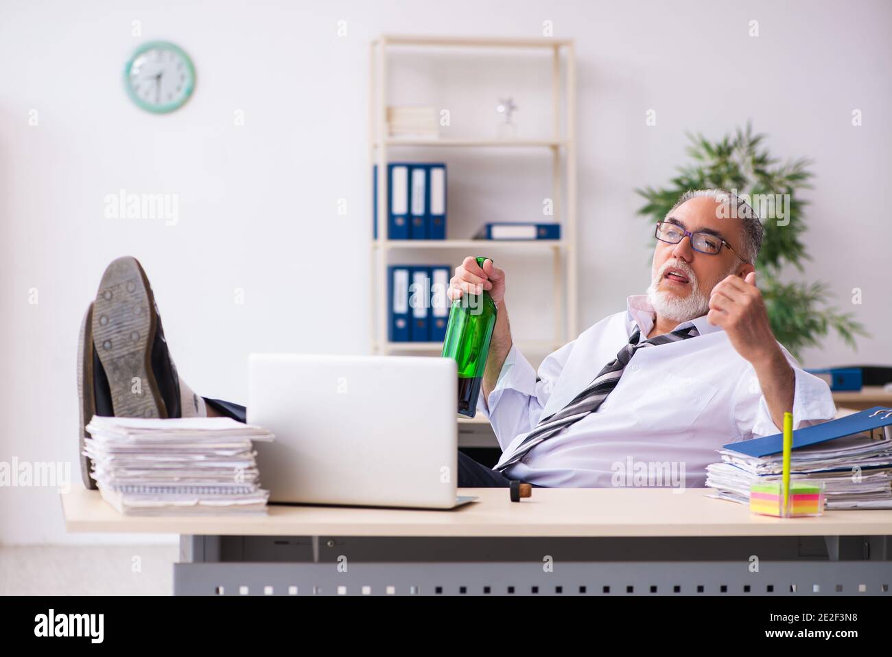Old businessman drinking alcohol in the office Stock Photo - Alamy
