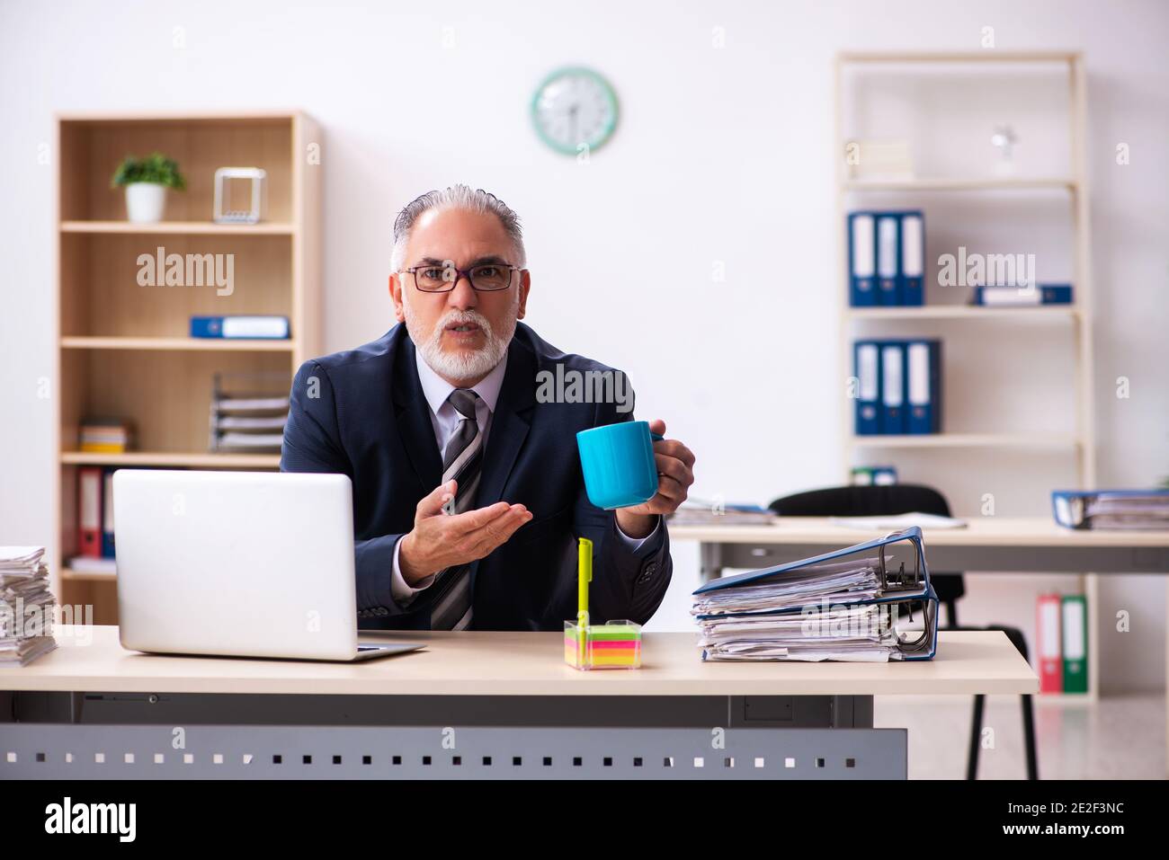 Old male employee drinking coffee at workplace Stock Photo - Alamy