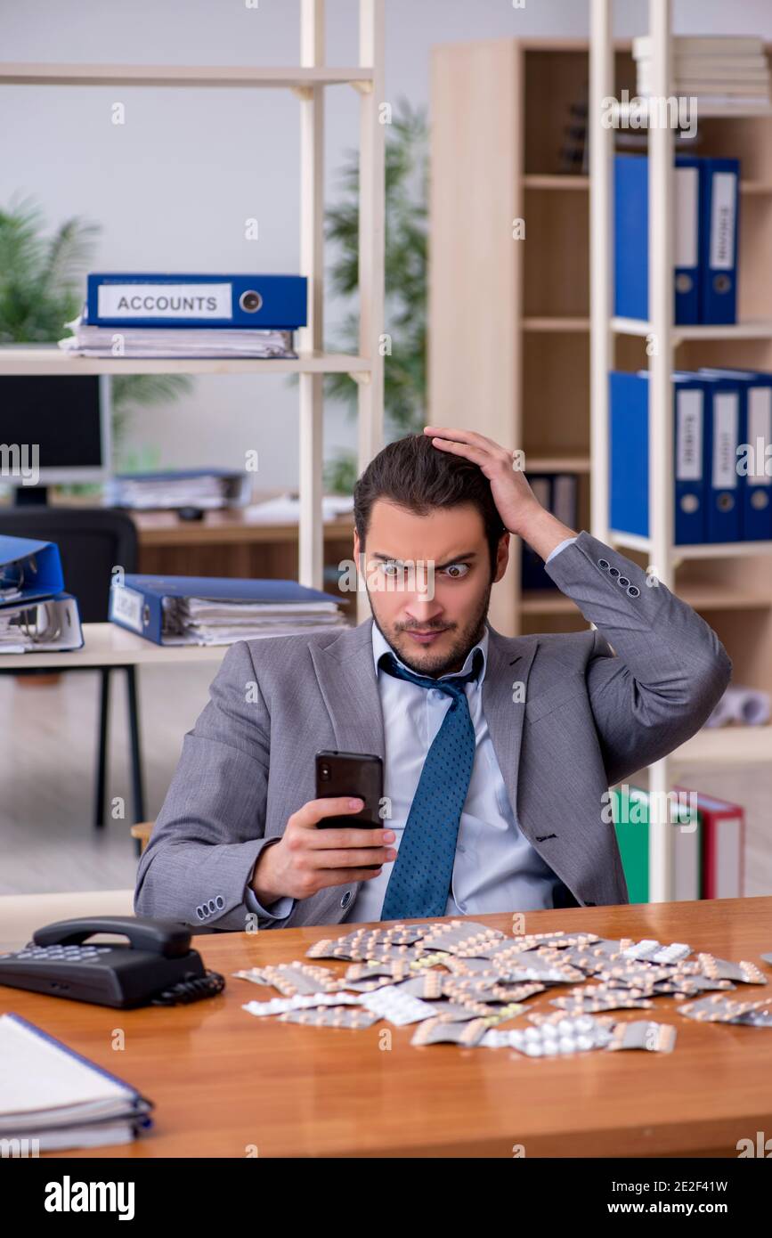 Male sick employee suffering at workplace Stock Photo - Alamy
