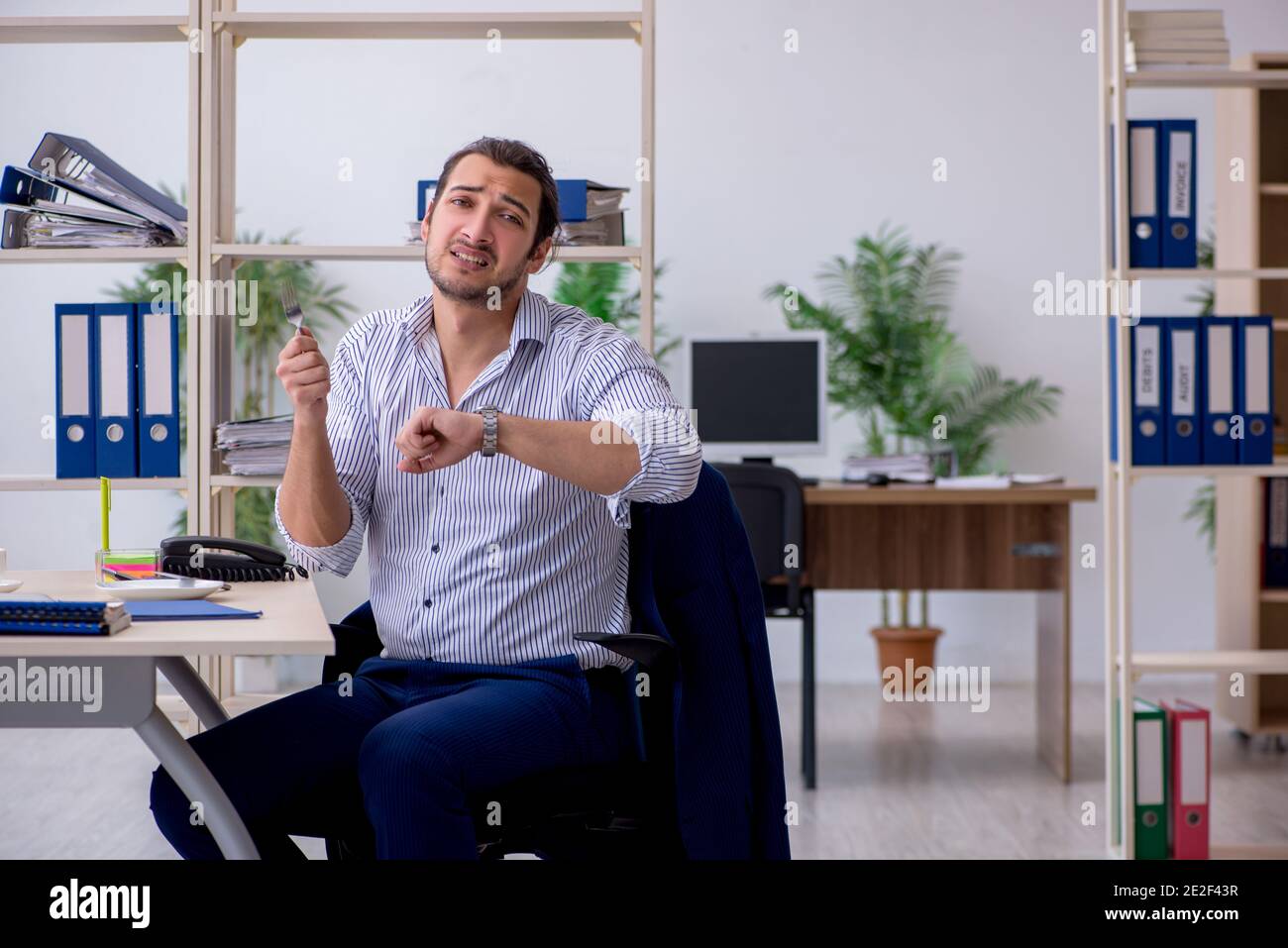 Hungry employee waiting for food in time management concept Stock Photo ...