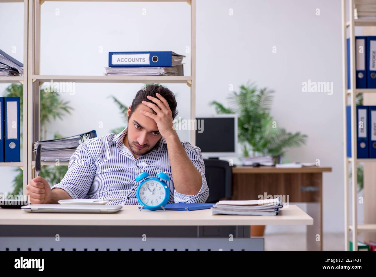 Hungry employee waiting for food in time management concept Stock Photo ...