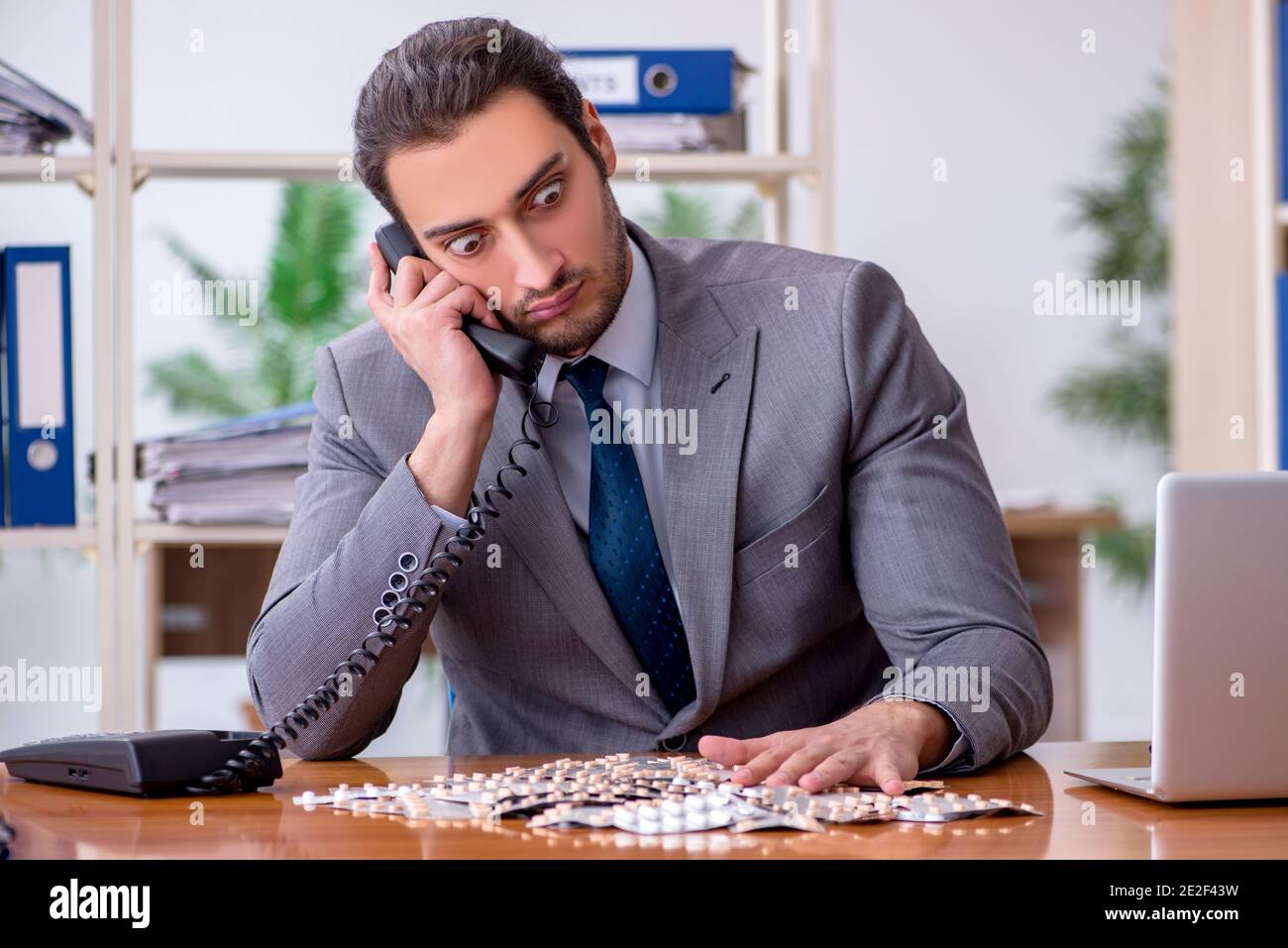 Male sick employee suffering at workplace Stock Photo - Alamy