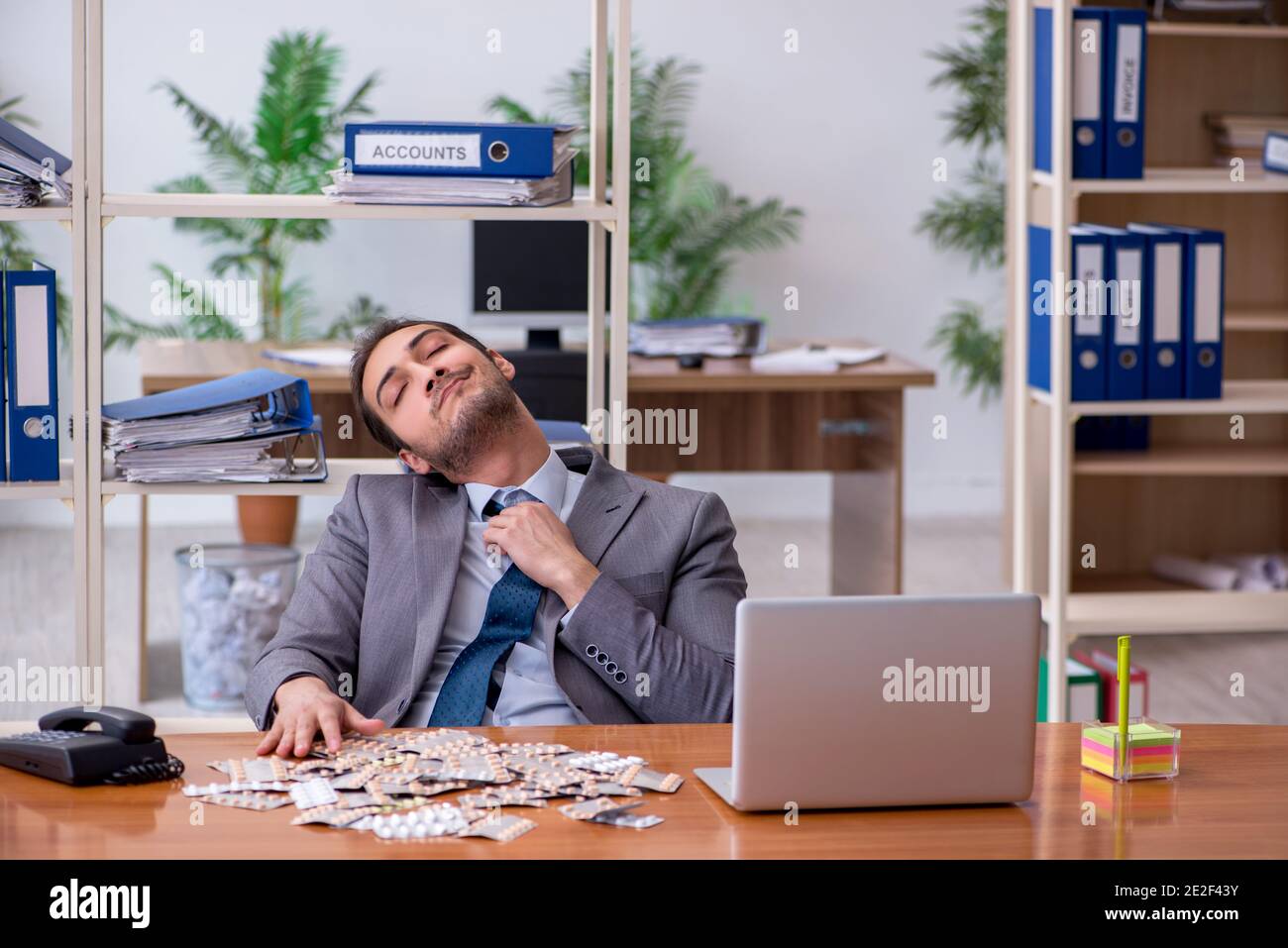 Male sick employee suffering at workplace Stock Photo - Alamy