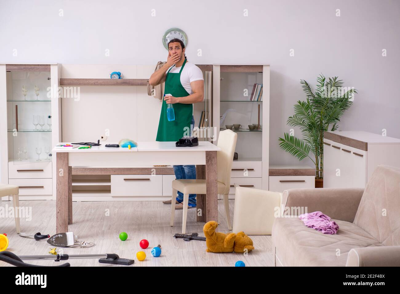 Young contractor cleaning the flat after kids' party Stock Photo - Alamy