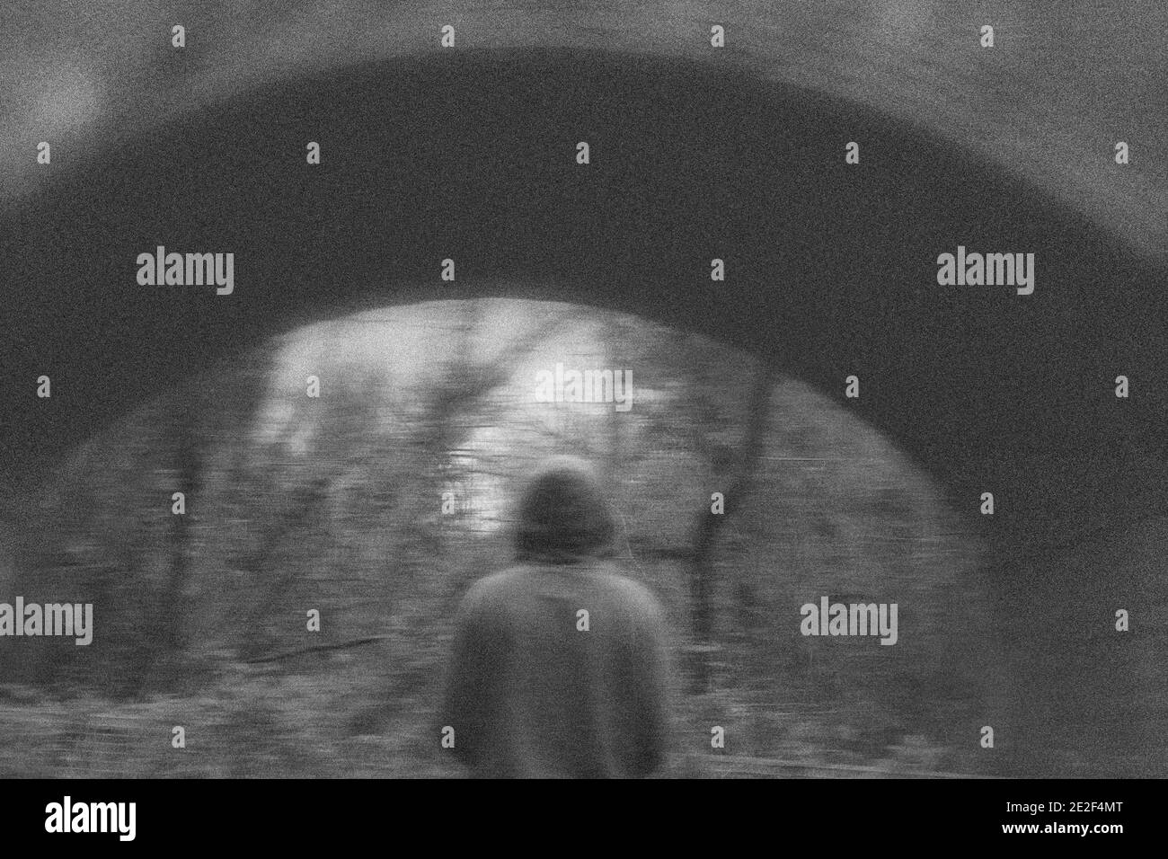 A moody dream like concept of a dark hooded figure standing underneath ...