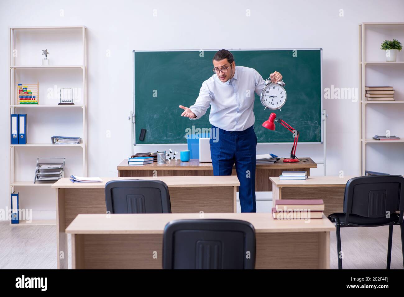 Young teacher in front of green board Stock Photo - Alamy