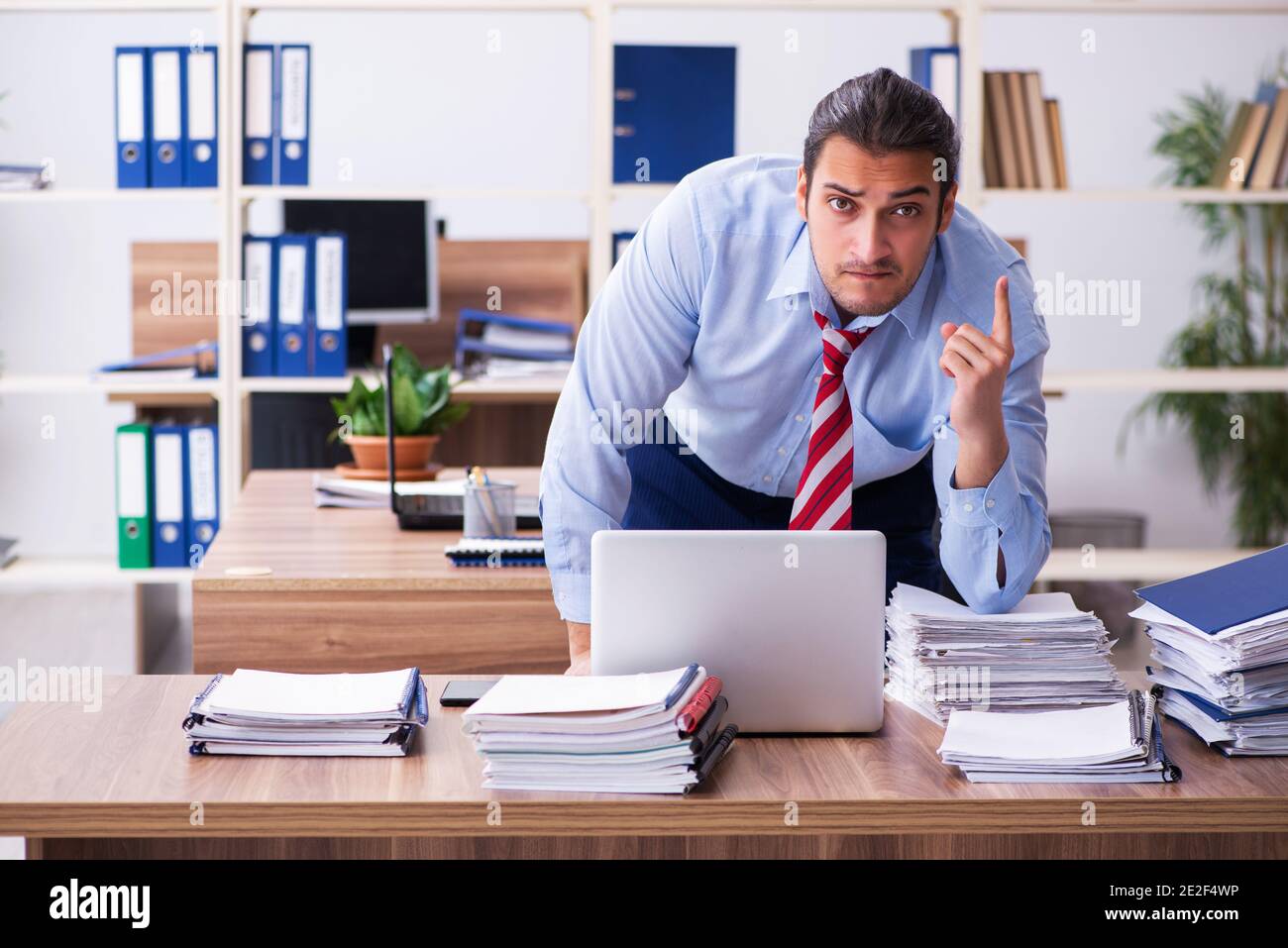 Young employee unhappy with excessive work Stock Photo - Alamy