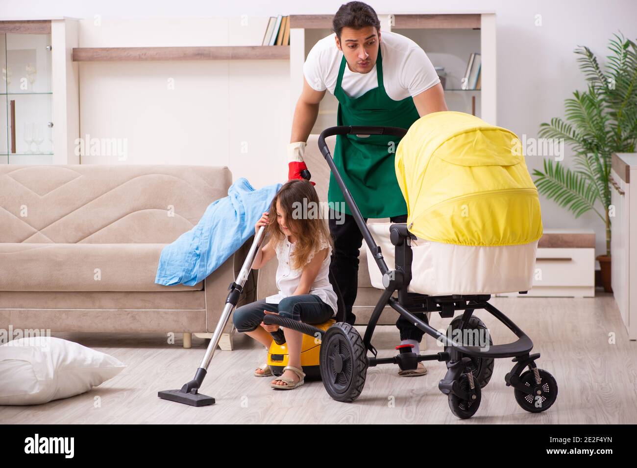 Young contractor cleaning the house with his small daughter Stock Photo ...