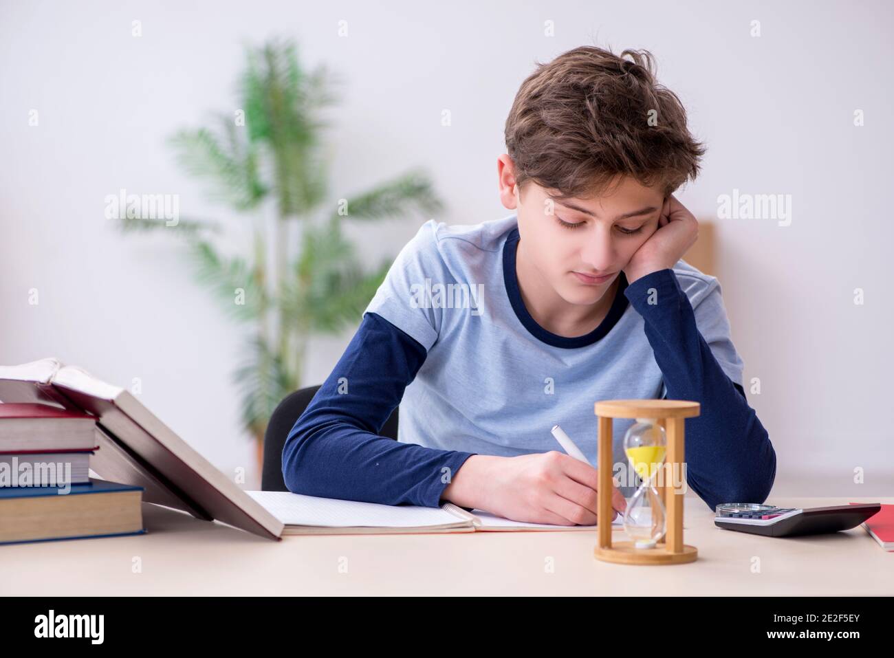 Boy preparing for exams in time management concept Stock Photo - Alamy