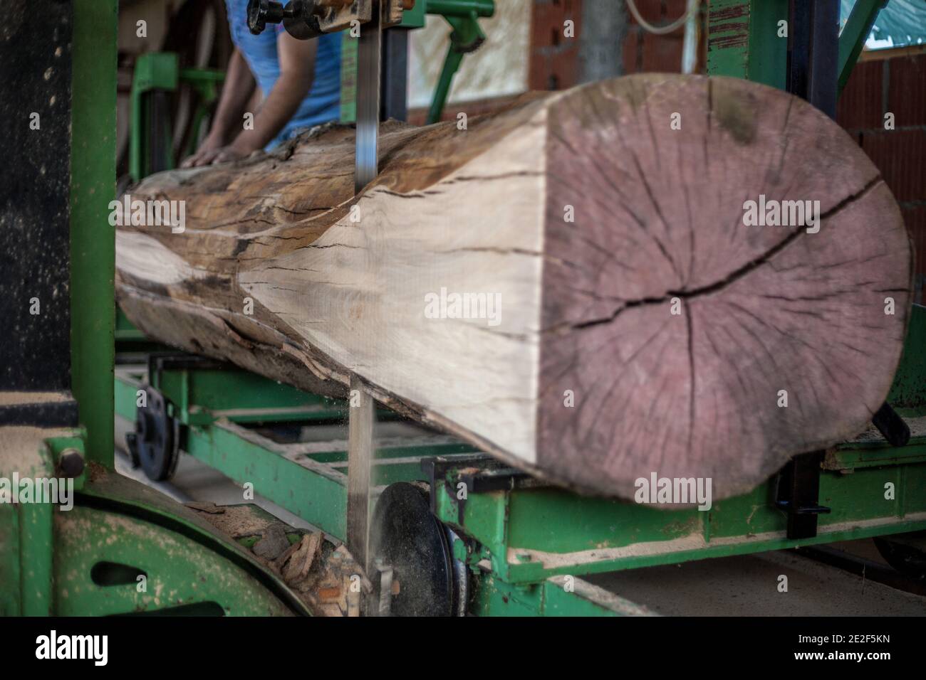 closeup shot of a thick log is about to be split into small pieces by ...