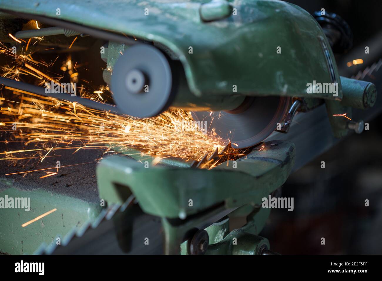 Industrial powerful machine cutting metal surface with sparks coming ...