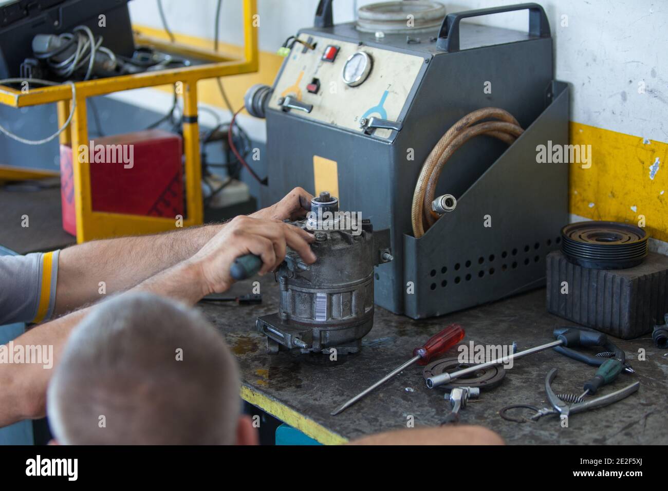 Caucasian male repairing a damaged part of a car with his working ...