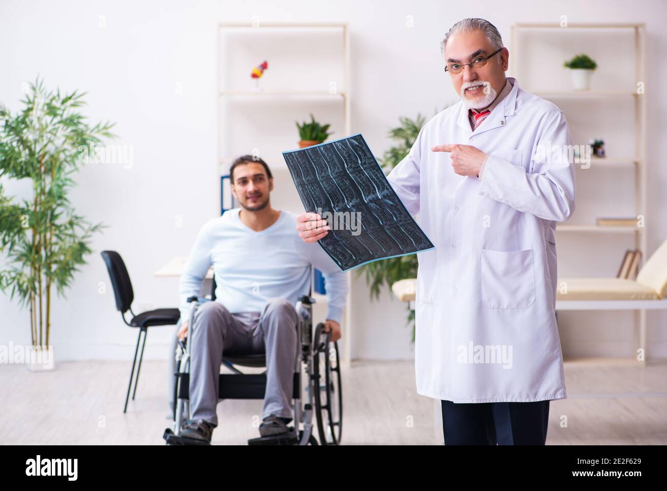 Man in wheel-chair and old doctor radiologist Stock Photo - Alamy