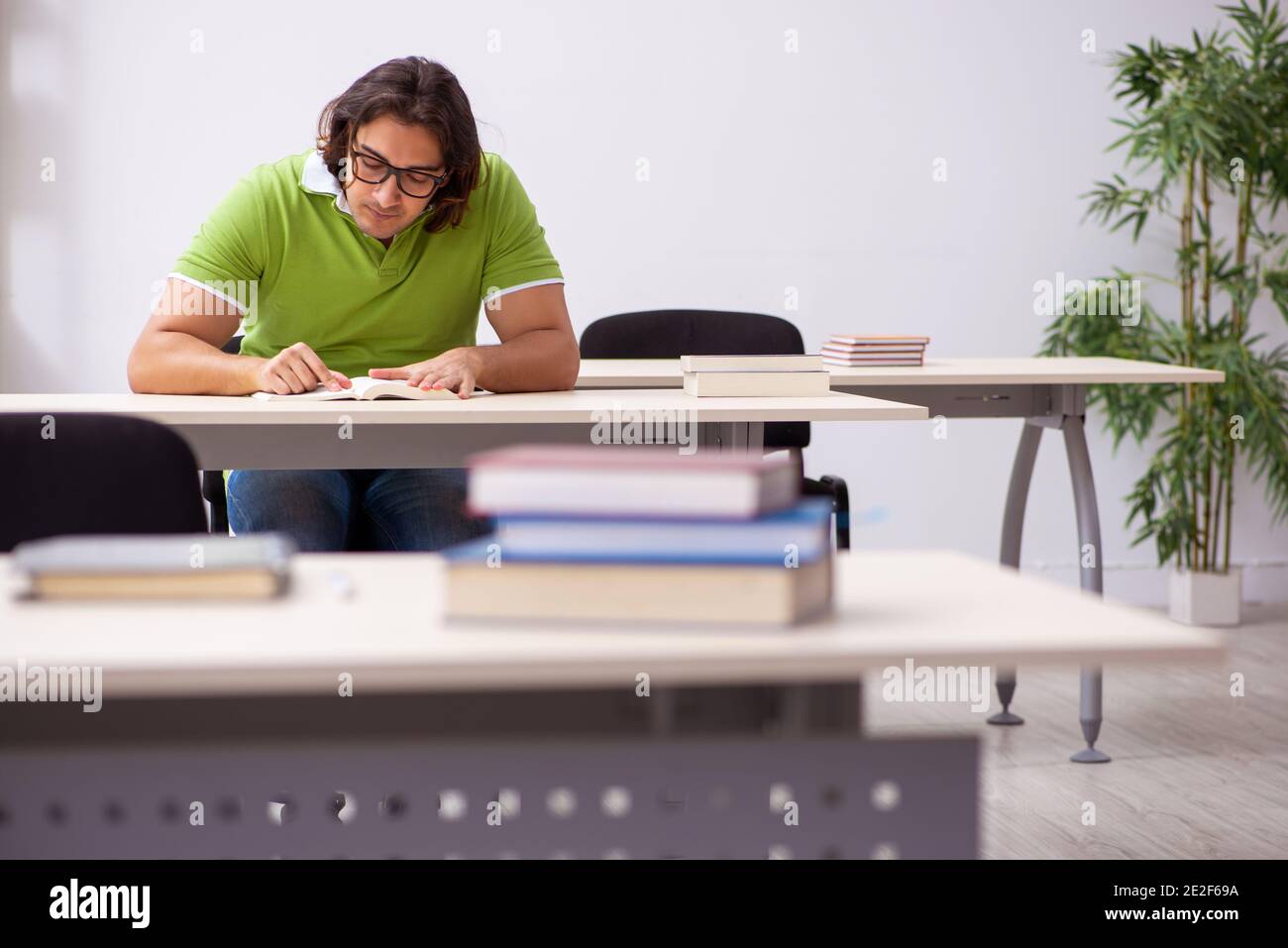 Young male student in the classroom studying Stock Photo - Alamy