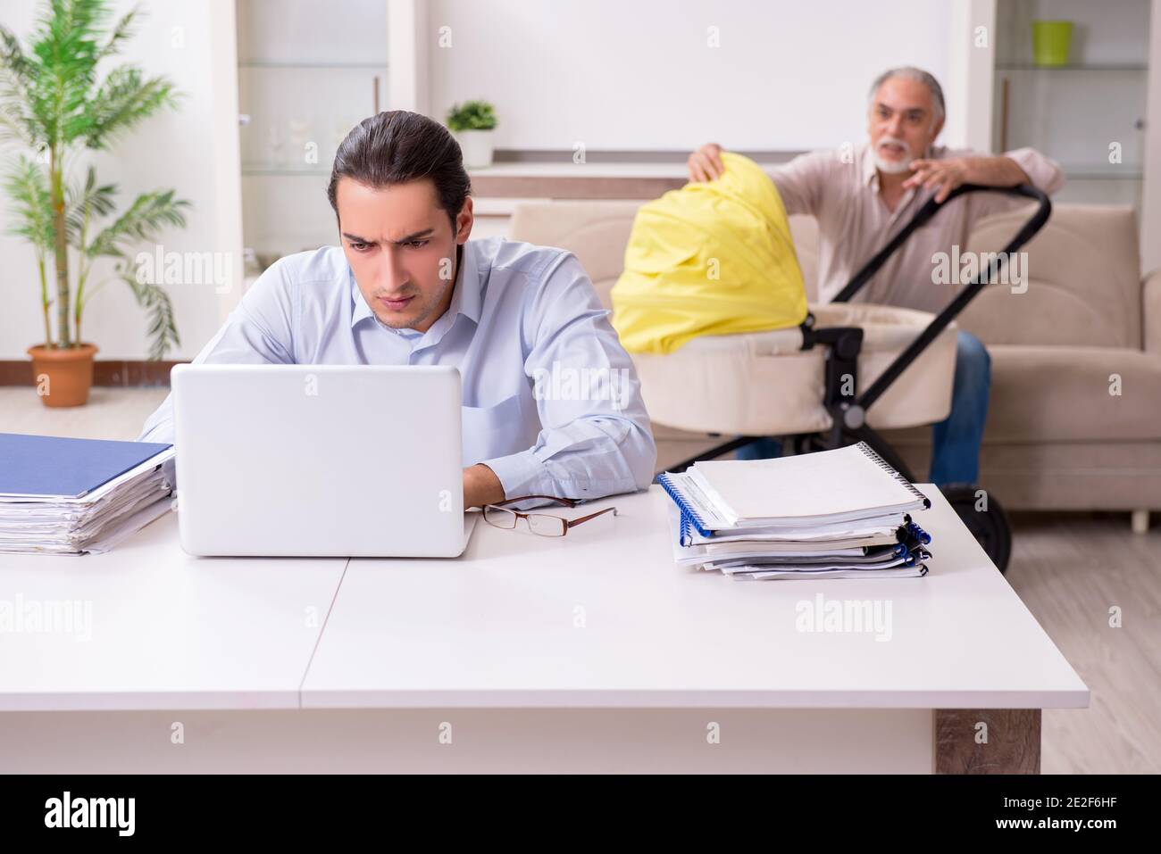 Old grandfather looking after newborn at home Stock Photo - Alamy