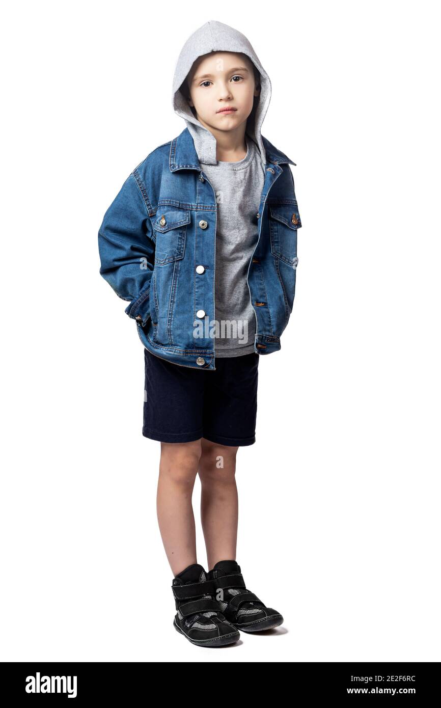 Portrait of sad boy in denim jacket, holds hands in pockets and is very ...