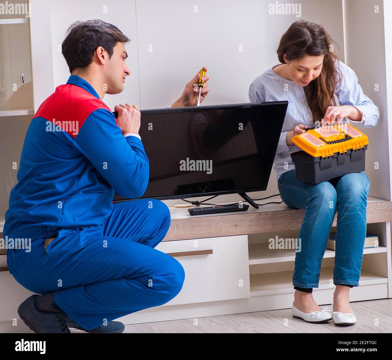 The repairman repairing tv at home Stock Photo - Alamy