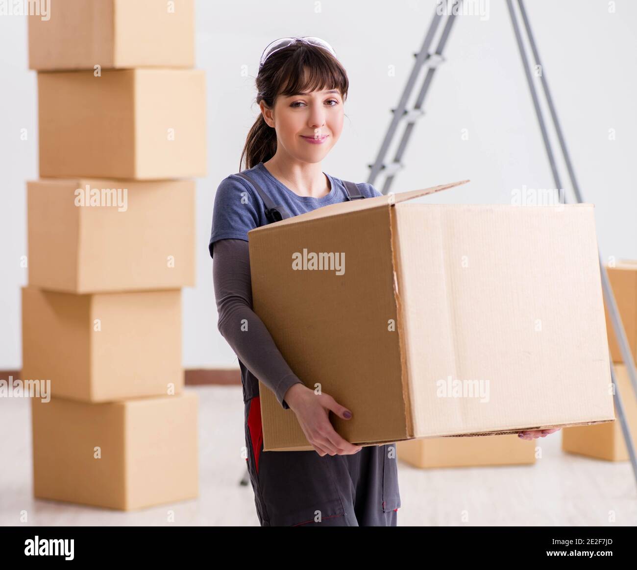 The woman contractor moving boxes in relocation concept Stock Photo - Alamy