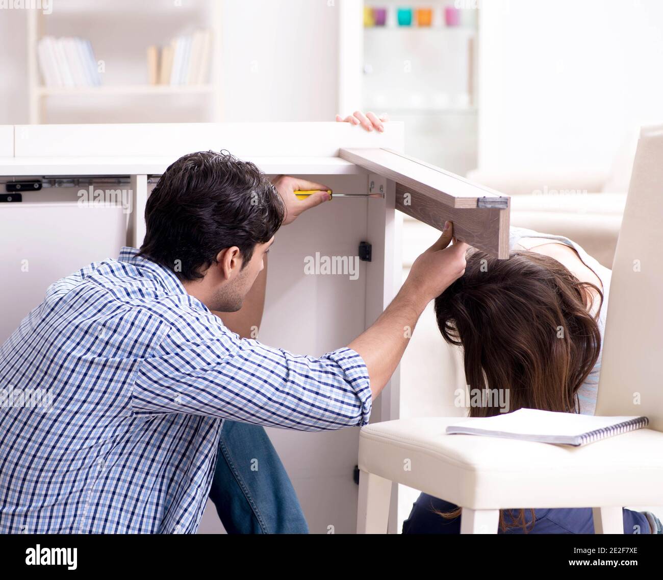 The husband repairing broken table at home Stock Photo - Alamy
