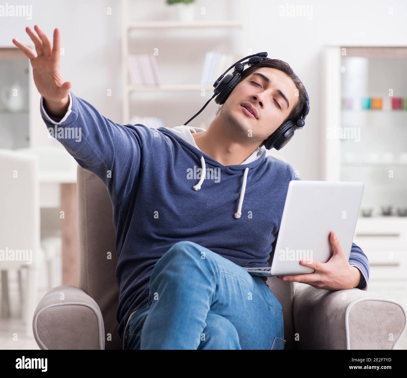 The young handsome man listening to music with headphones Stock Photo ...