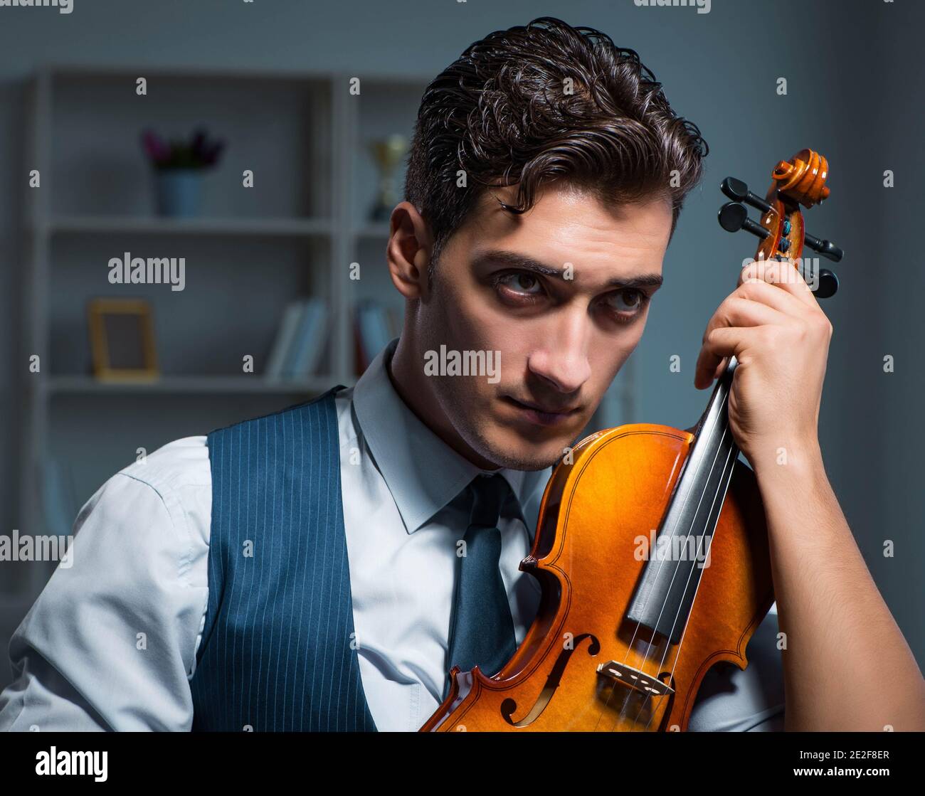 The young musician man practicing playing violin at home Stock Photo ...