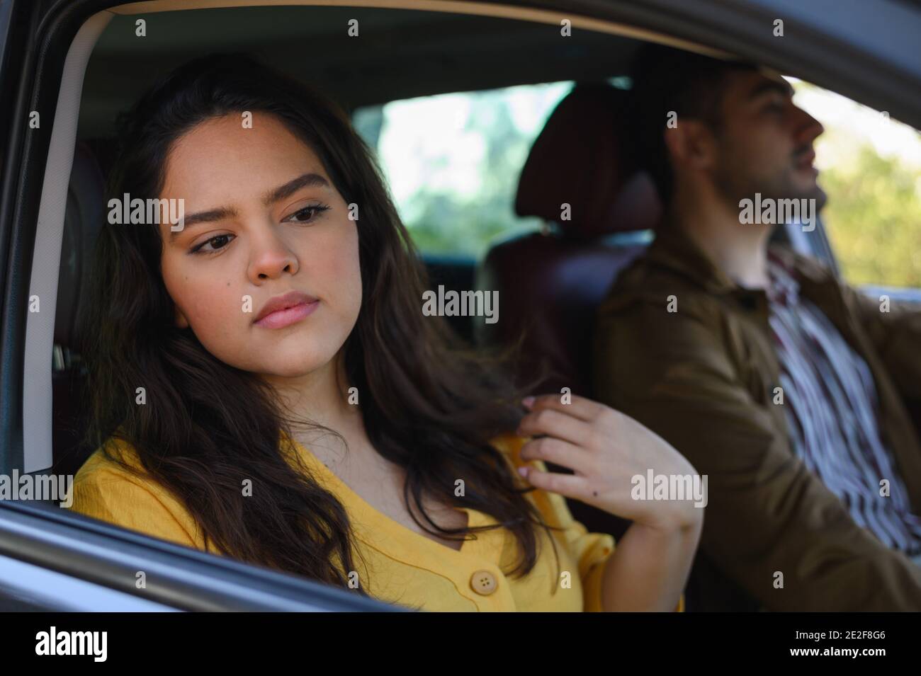 Shallow focus of a young Hispanic couple driving a car under the ...