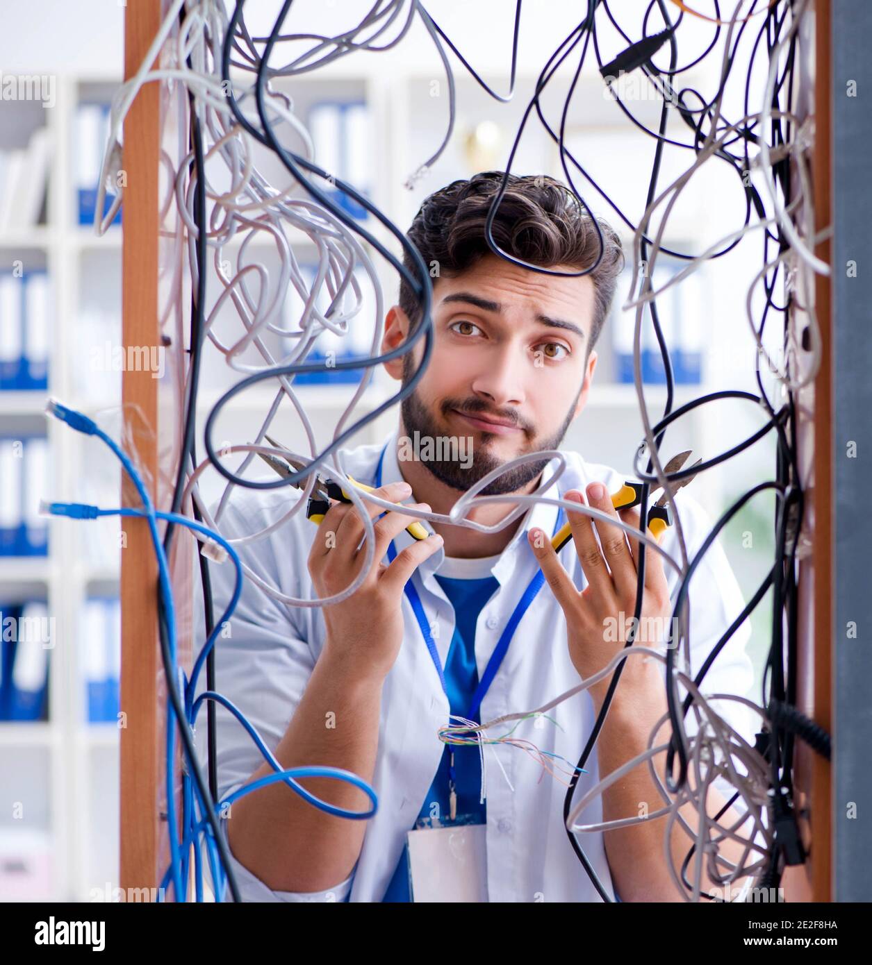 The electrician trying to untangle wires in repair concept Stock Photo ...