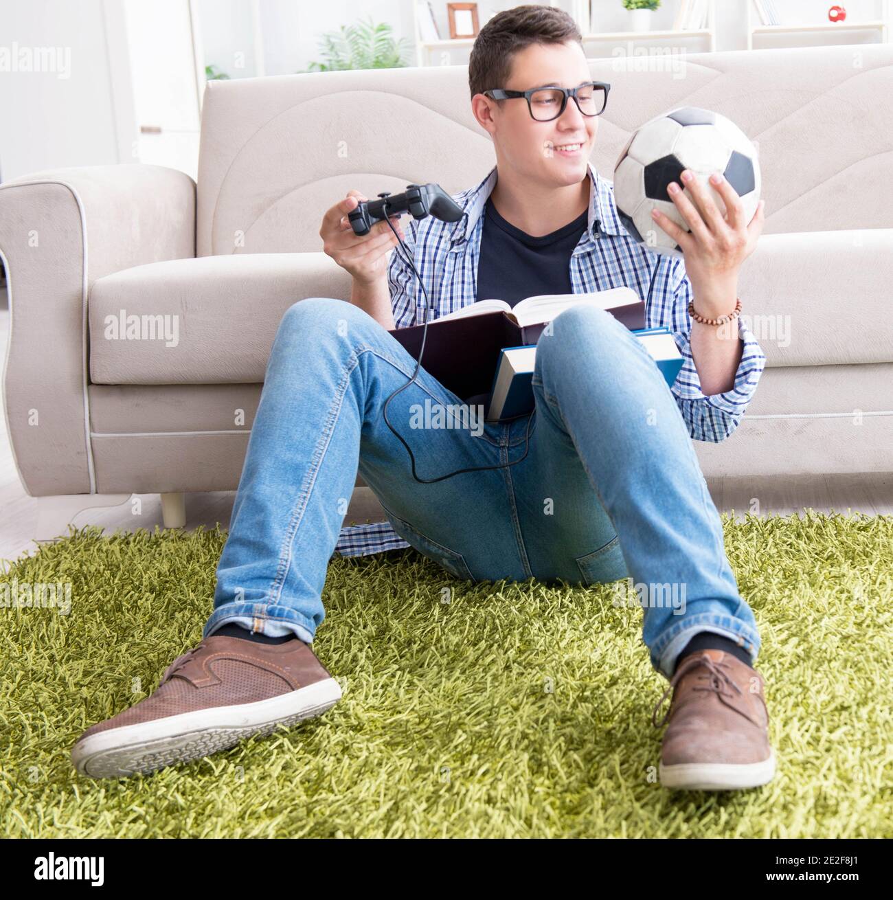 The young student trying to balance studying and playing games Stock ...