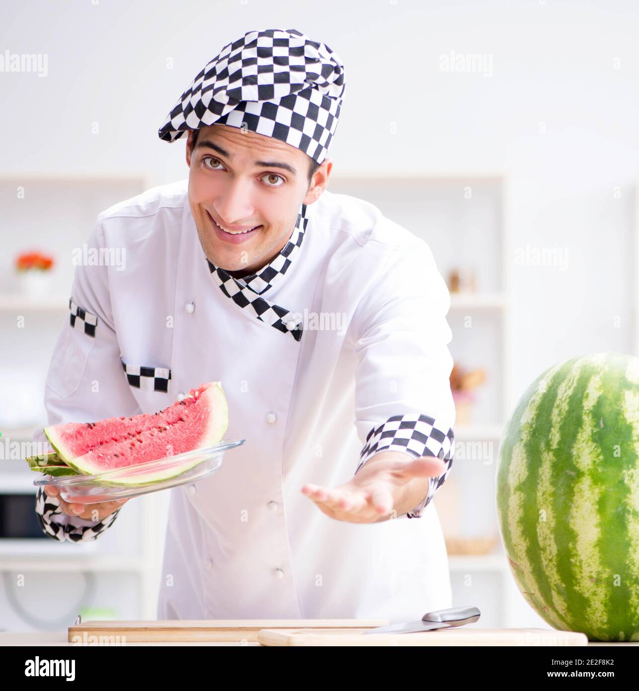The male cook with watermelon in kitchen Stock Photo - Alamy