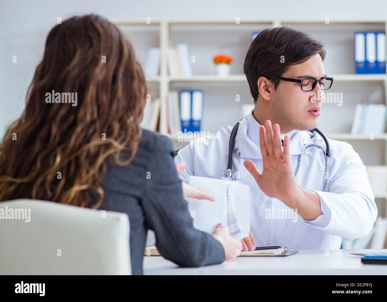 The young doctor in medical insurance fraud concept Stock Photo - Alamy