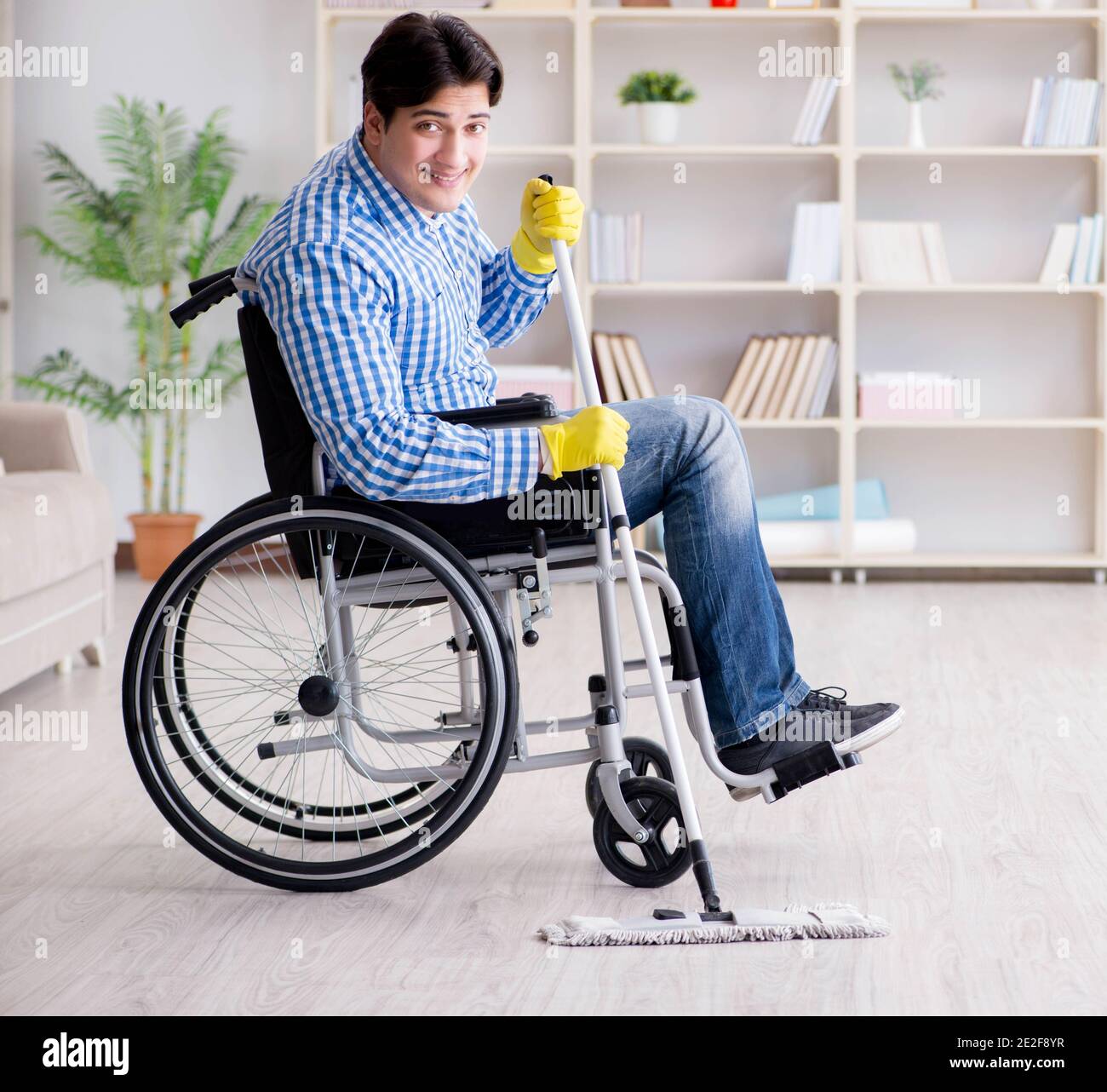 The disabled man on wheelchair cleaning home Stock Photo - Alamy
