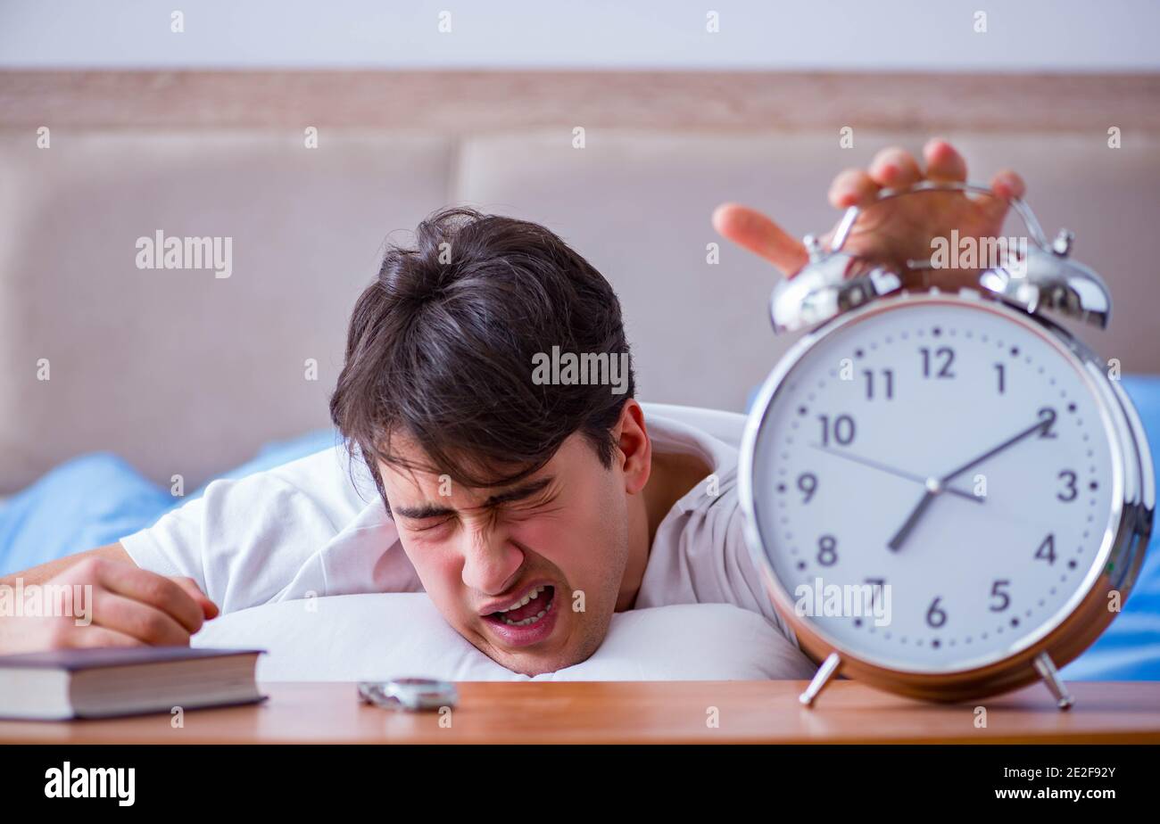Man in bed frustrated suffering from insomnia with an alarm clock Stock ...