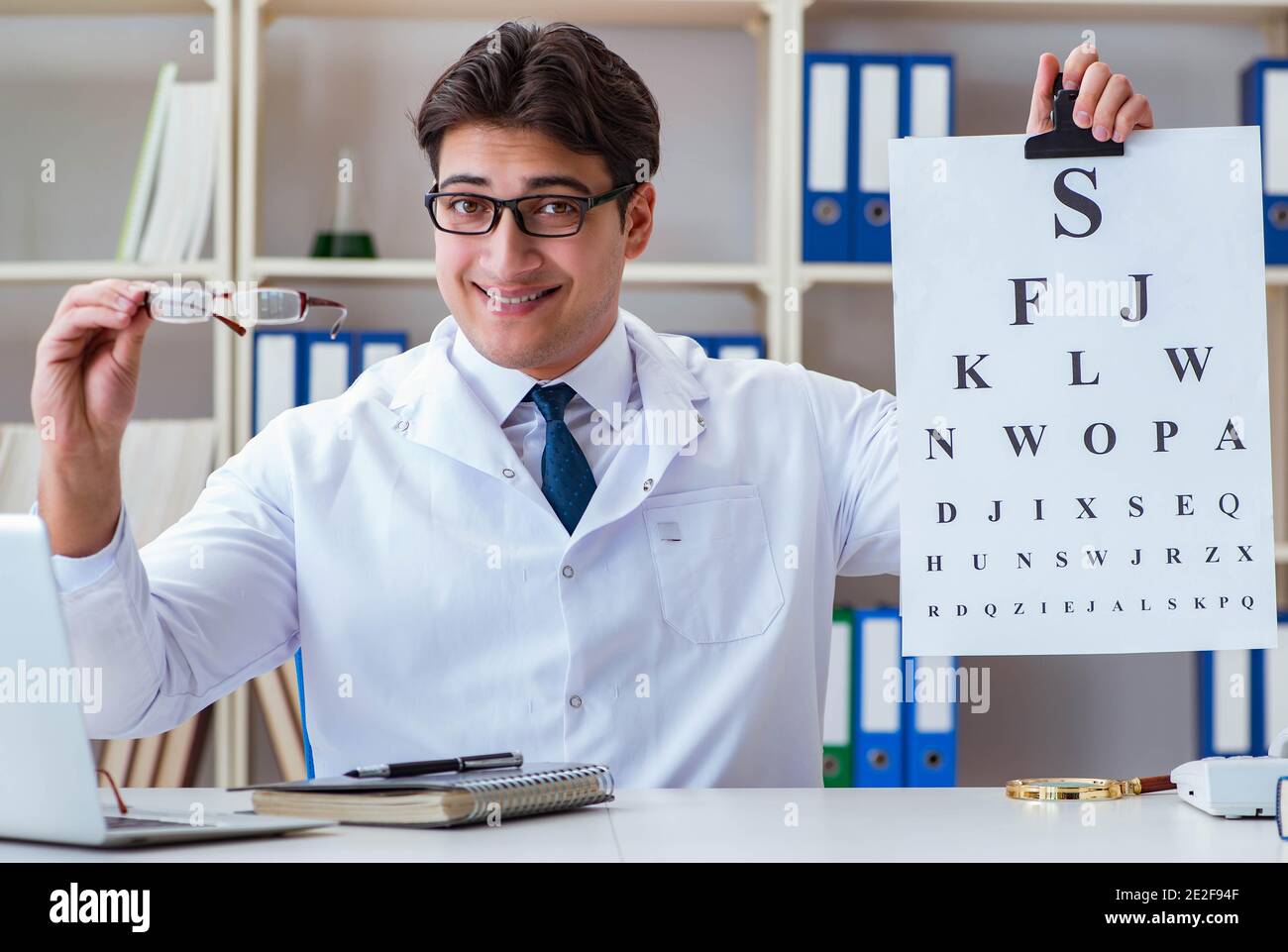 The doctor optician with letter chart conducting an eye test check ...