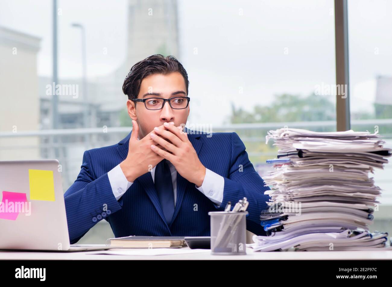 The workaholic businessman overworked with too much work in office ...