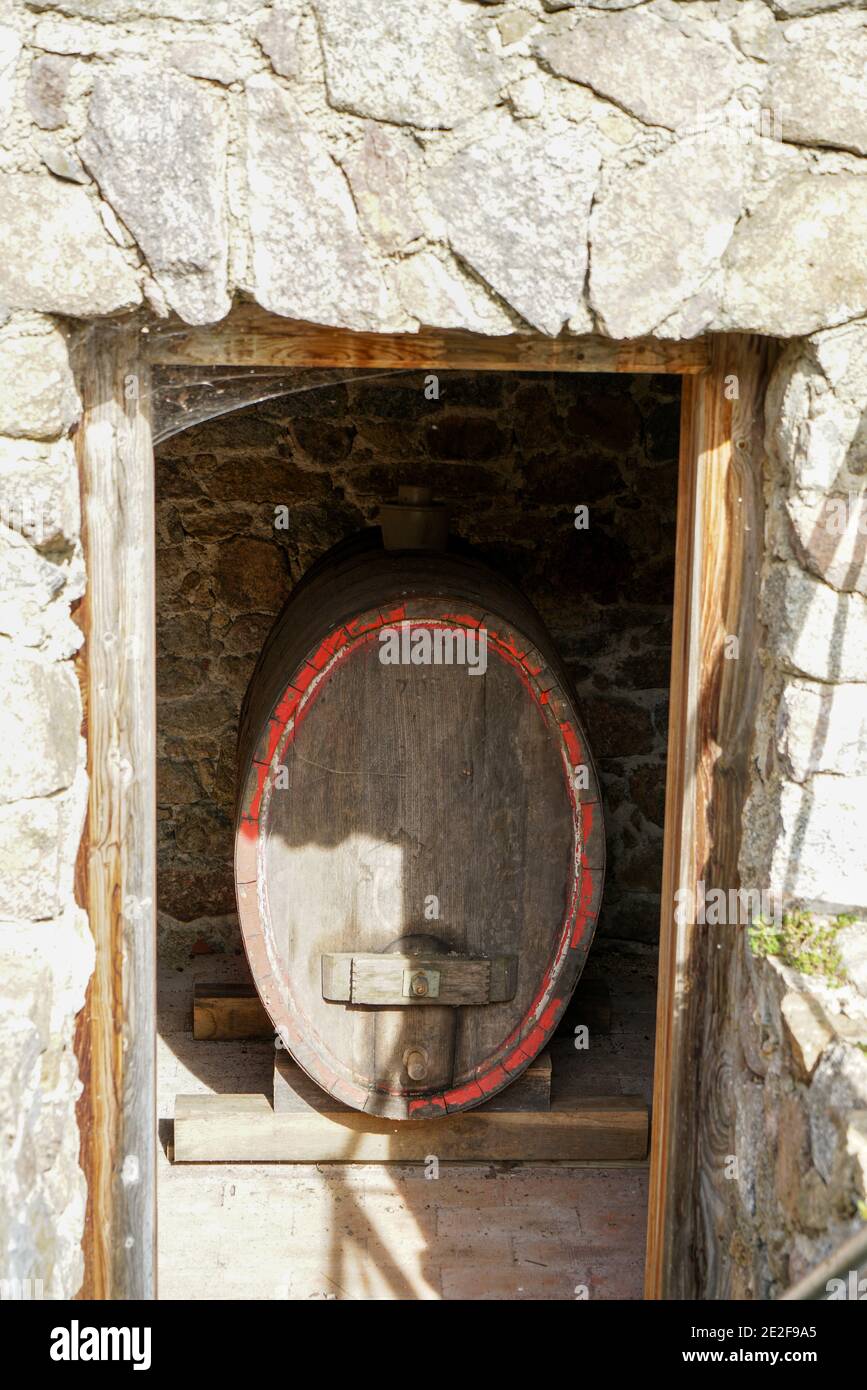 Vertical shot of an old wooden barrel in a stone wall hole Stock Photo ...