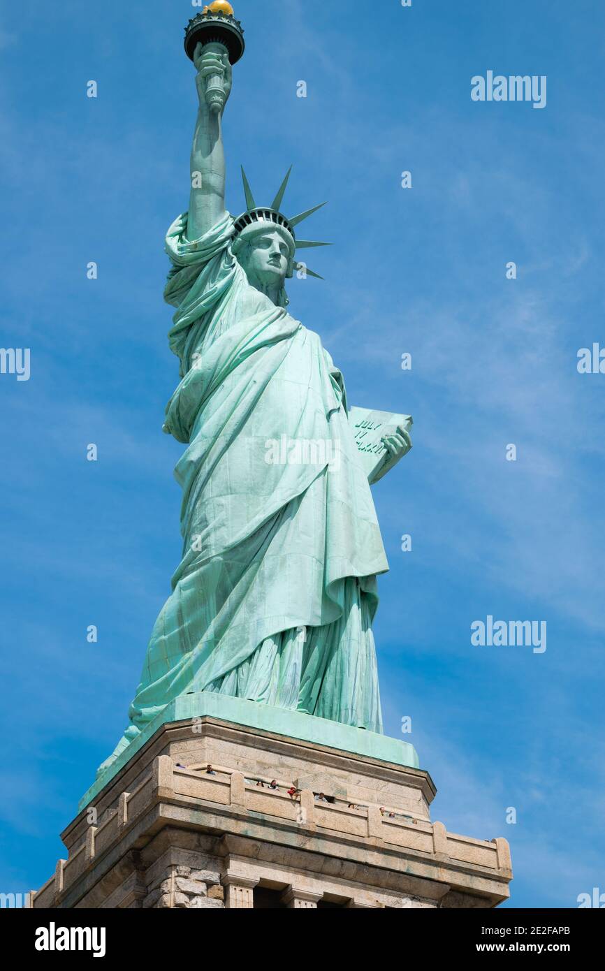 Vertical shot of The Statue of Liberty under a blue sky in New York ...