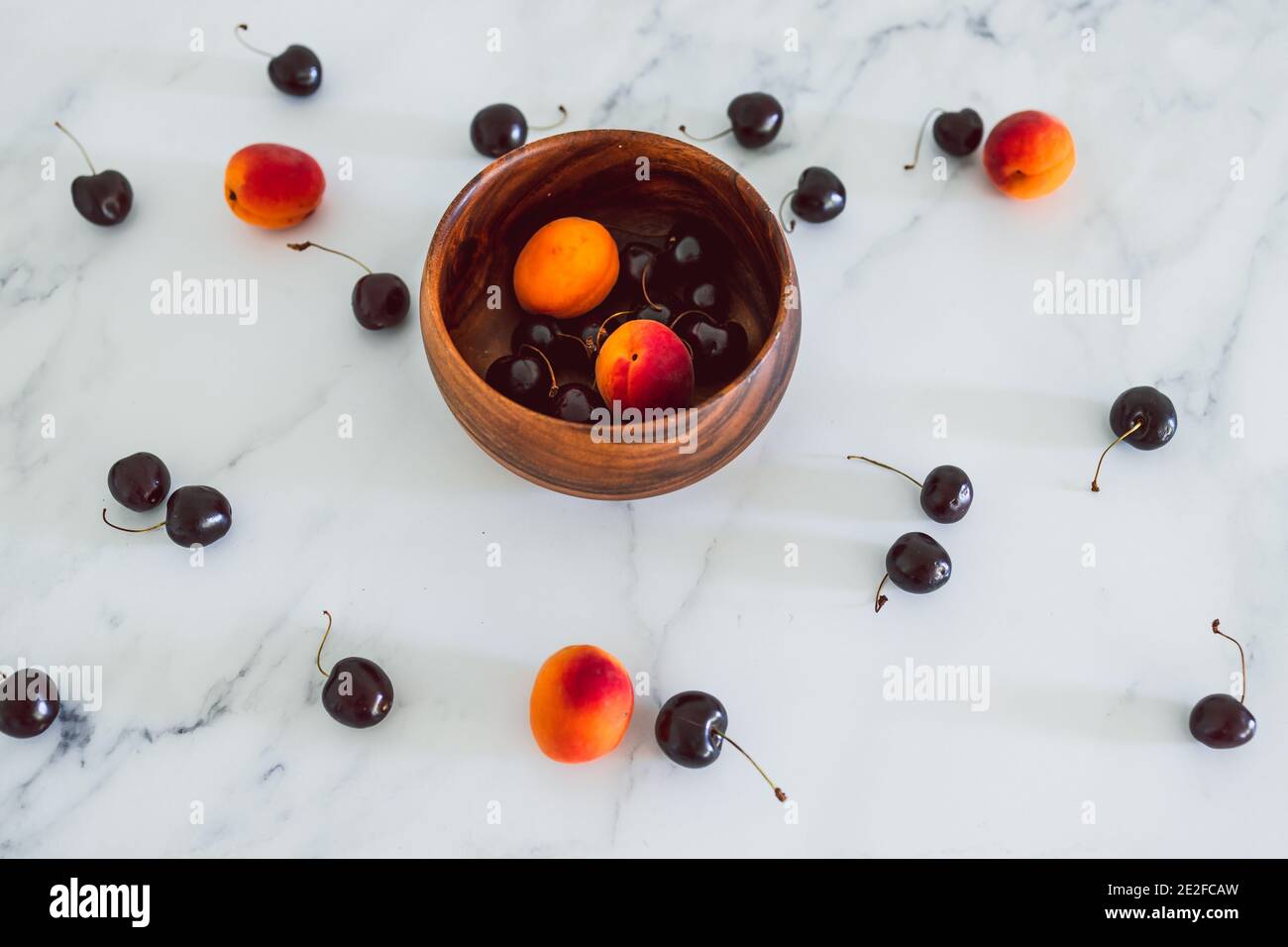 simple food ingredients concept, fresh apricots and cherries on marble ...
